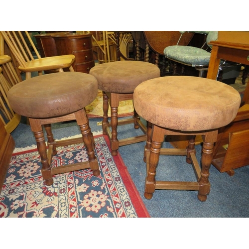 THREE UPHOLSTERED PUB STOOLS
