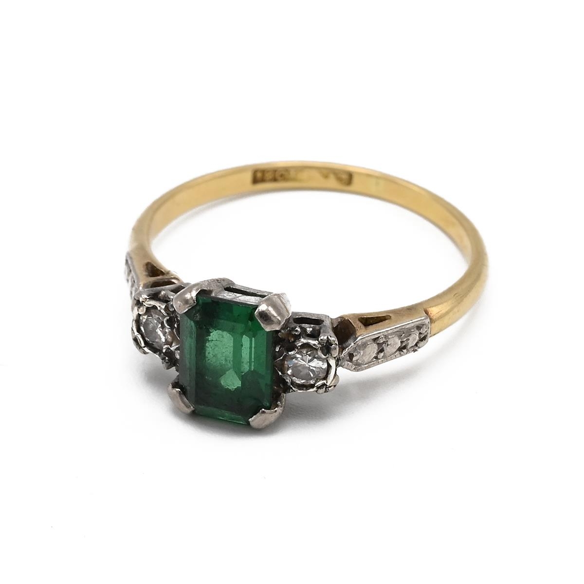 An 18ct yellow gold emerald and diamond ring, the rectangular mixed cut ...