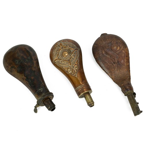 Three antique shot flasks. Two in brass, one with stamped design to ...