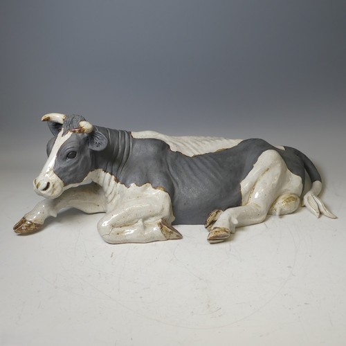 A very large pottery figure of a recumbent Cow, tail damaged and ...