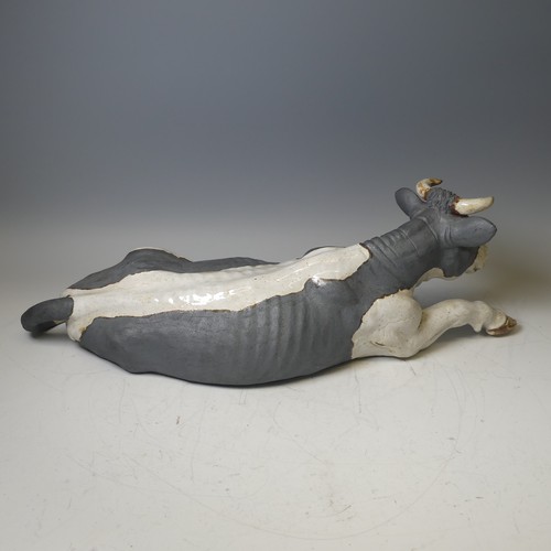 A very large pottery figure of a recumbent Cow, tail damaged and ...