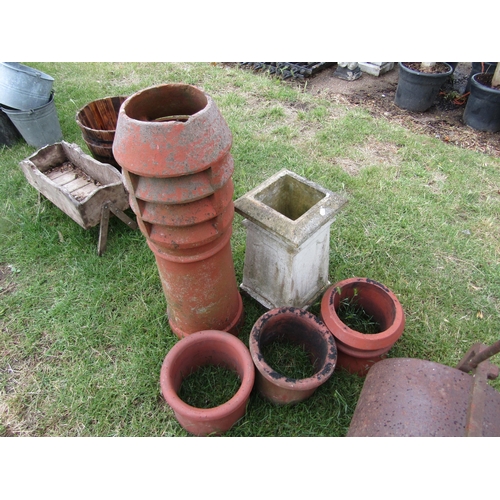 A vented chimney pot, square buff chimney pot and three others