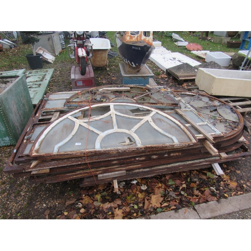 A pallet of mixed cast iron framed windows including arch top