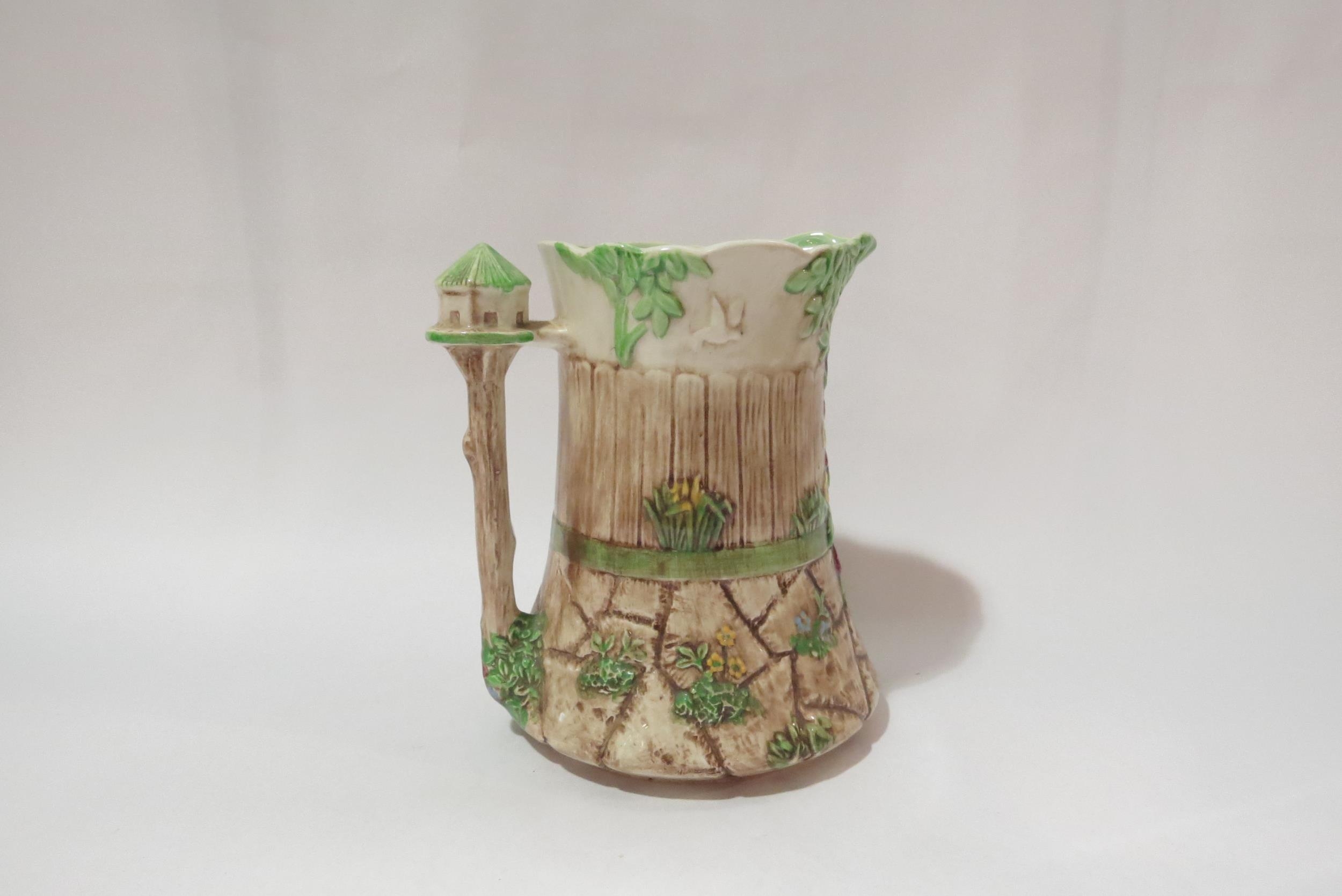A Falcon Ware jug, handle as dovecote, decorated in high relief with ...