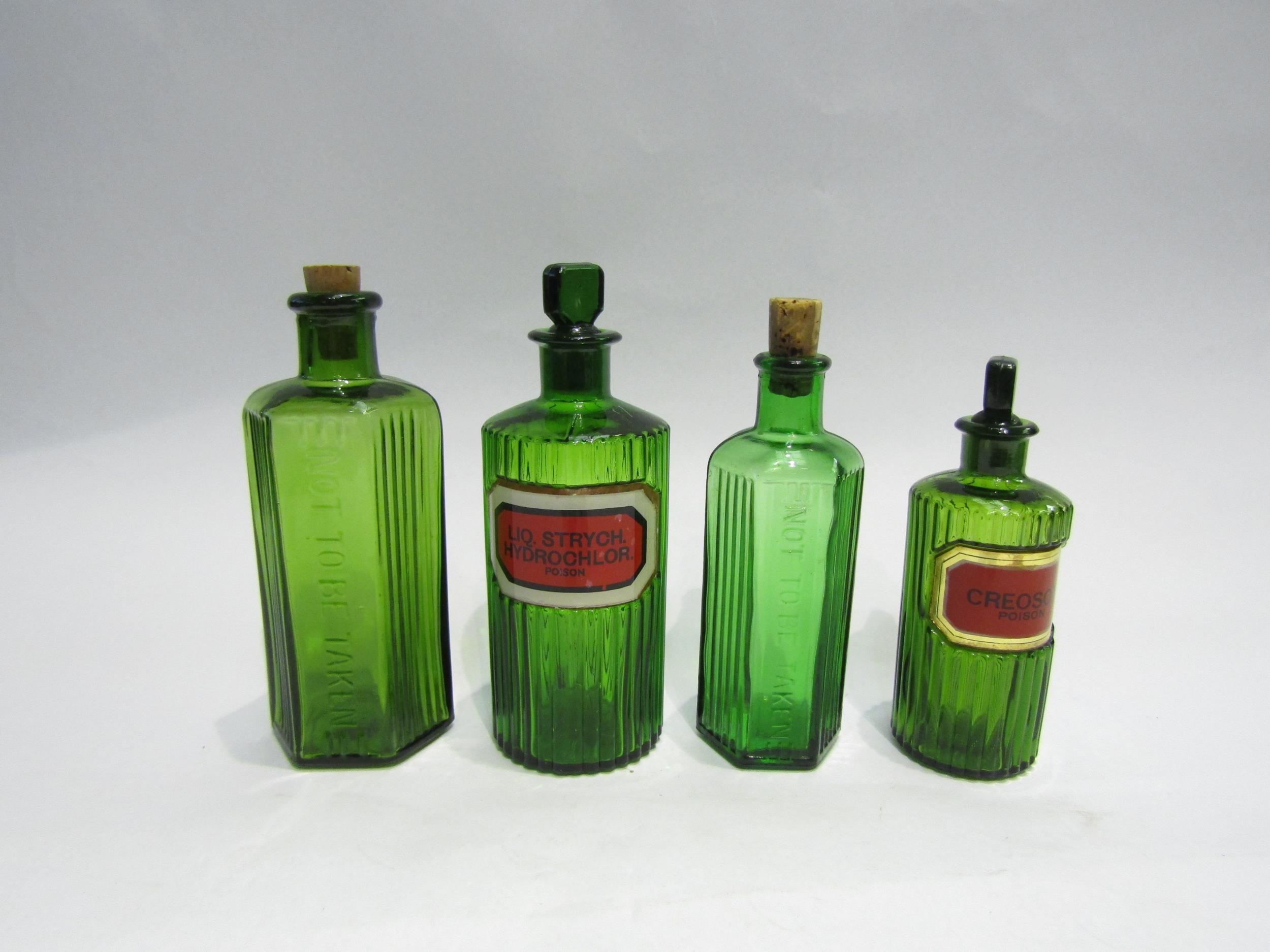 Four green glass poison bottles, two with original labels