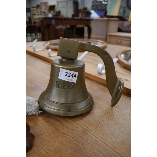 A brass wall mounting ships bell and bracket