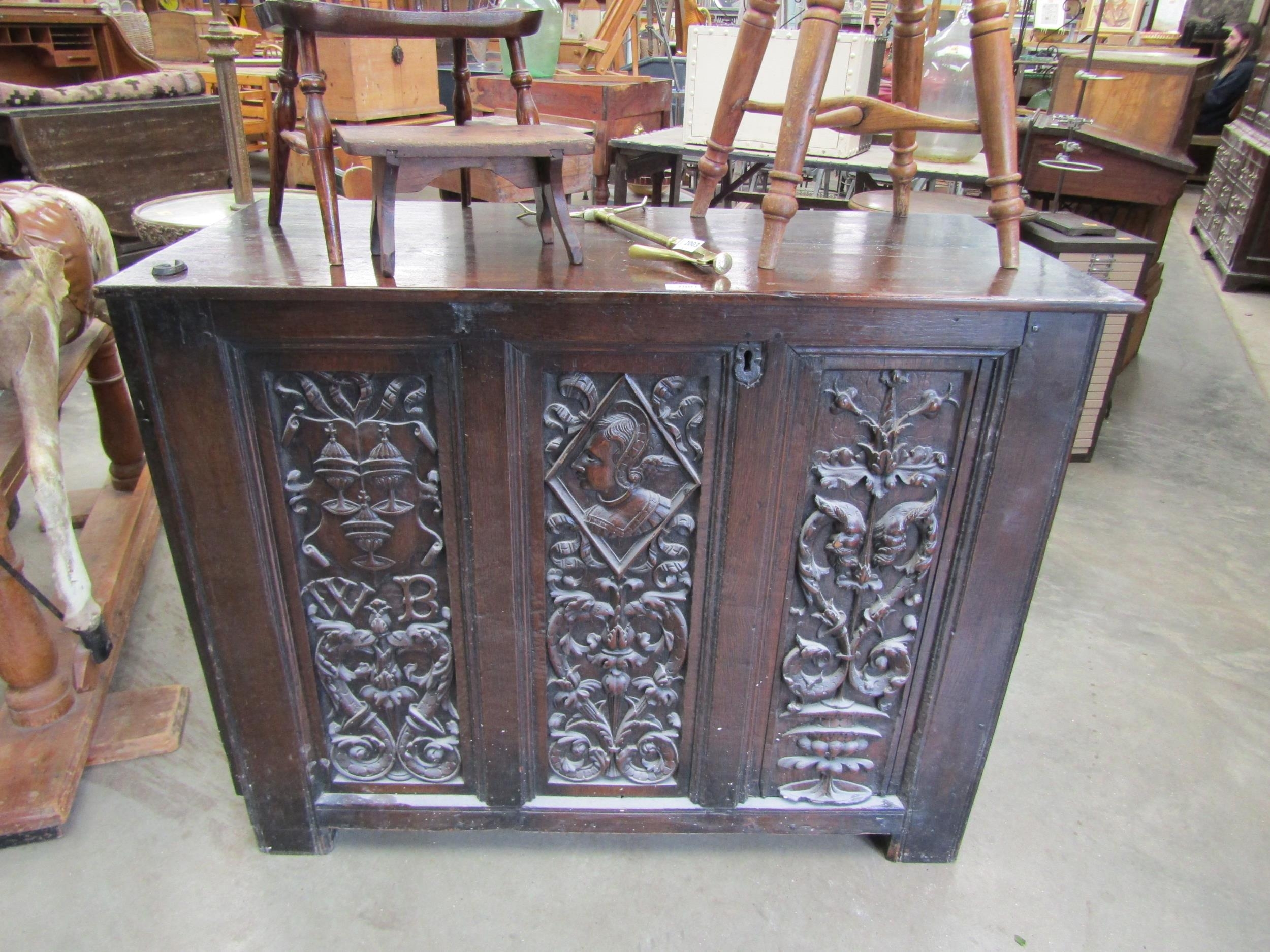 A 17th Century oak credence cupboard, heavily carved religious front ...