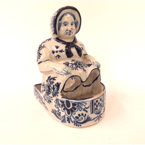 A late 19th century Dutch delft figurine with raised skirt and finger ...