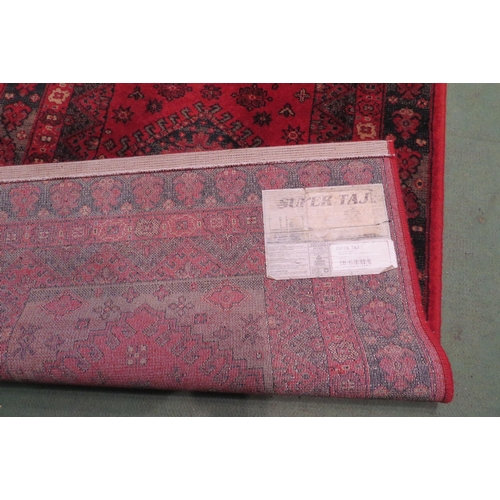 A Super Taj Belgian red ground wool rug with multiple borders, 156cm x 83cm