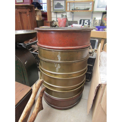 A rack of six brass sieves