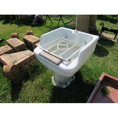 A glazed pedestal boot sink with chrome rack