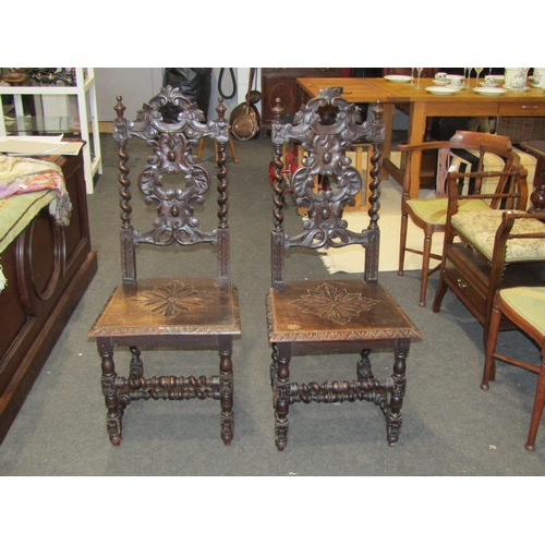 A pair of ornate carved oak chairs, spiral twist form supports and ...