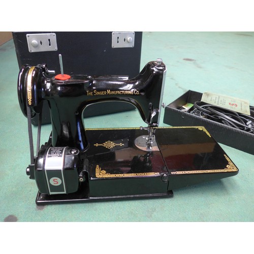 A cased Singer Portable electric sewing machine No.221K1