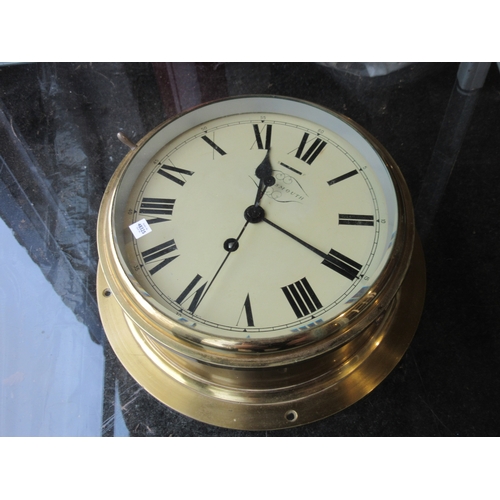 A brass cased ship's clock marked Portsmouth, Roman numeral dial
