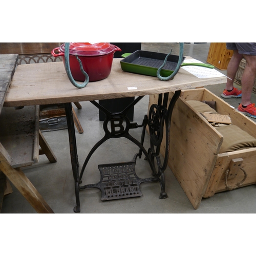 A cast iron sewing machine base table with elm top