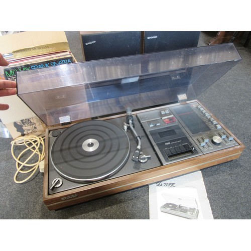 A Sharp record player with two speakers together with some jazz singles
