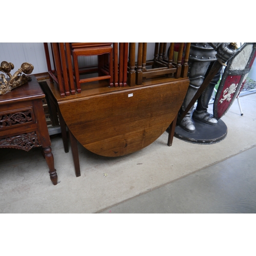 A Georgian oak drop-flap oval dining table