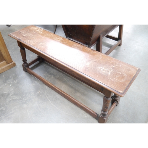 A 17th Century style oak coffin stool, 124cm long