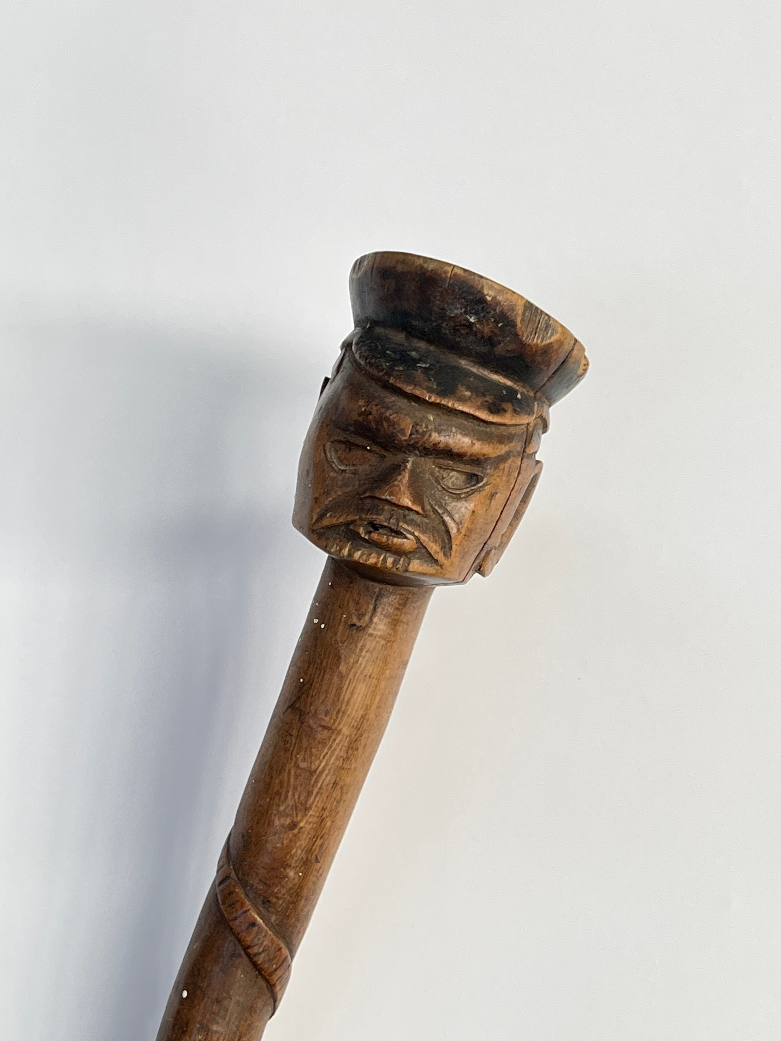 A prisoner of war carved walking stick with soldier head knop