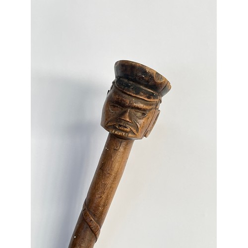 A prisoner of war carved walking stick with soldier head knop