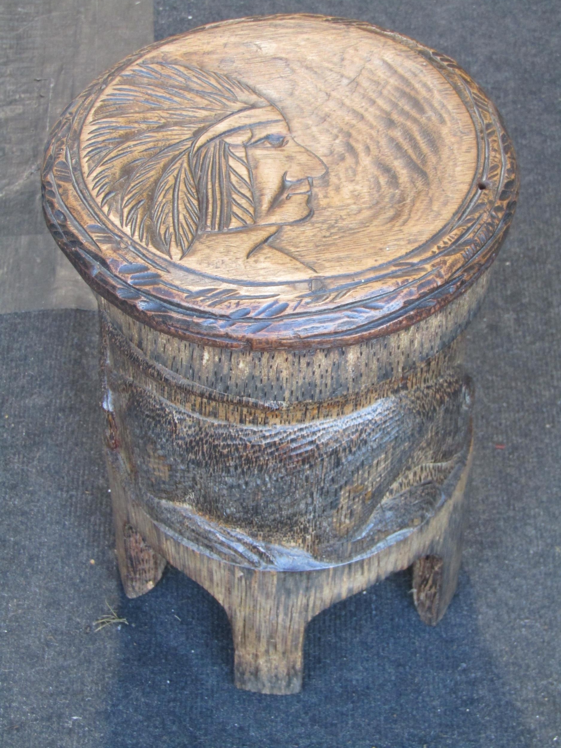 A carved wooden five legged stool with big cats to side panel and ...