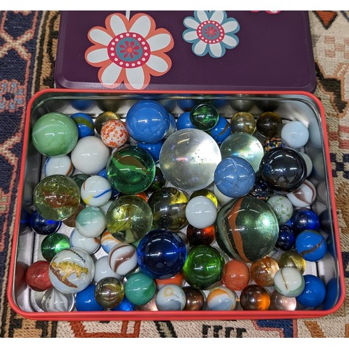 Tin of assorted glass and metal marbles
