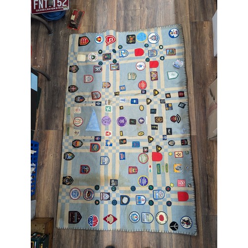Large vintage blanket with assorted patches and badges, mainly girl guides