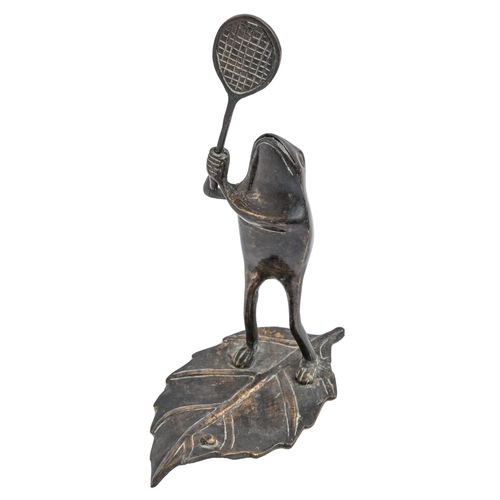 An anthropomorphic patinated brass sculpture of a frog holding a tennis ...