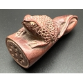 A carved wooden Japanese netsuke of a frog sat on a log. Set with ...