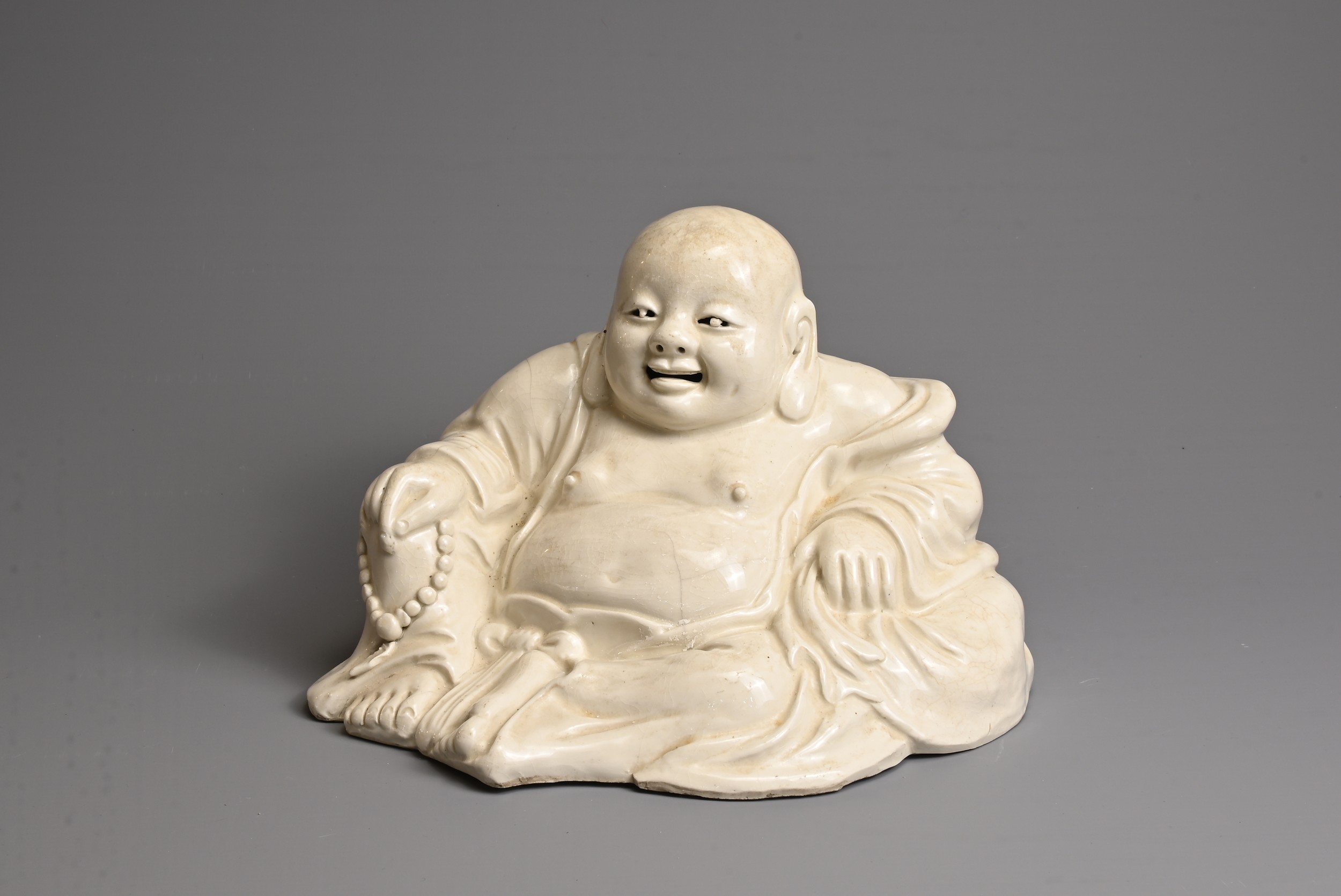 A CHINESE BLANC DE CHINE PORCELAIN FIGURE OF BUDAI, 19/20TH CENTURY ...