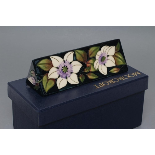 A MOORCROFT POTTERY SIGN, 2002, of triangular section, one side moulded ...