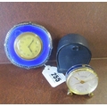 SILVER AND ENAMEL DRESSING TABLE CLOCK AND A LOOPING TRAVEL ALARM CLOCK