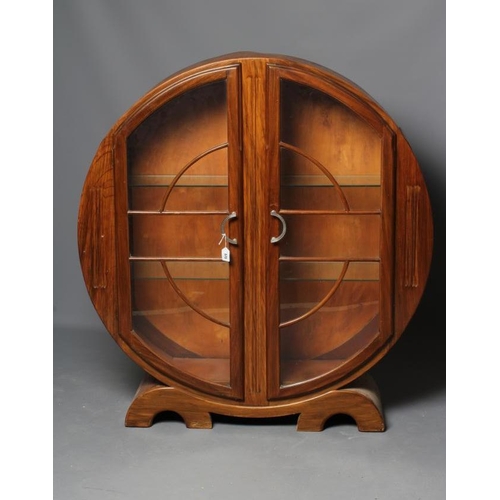 AN ART DECO WALNUT DISPLAY CABINET of circular outline with two ...