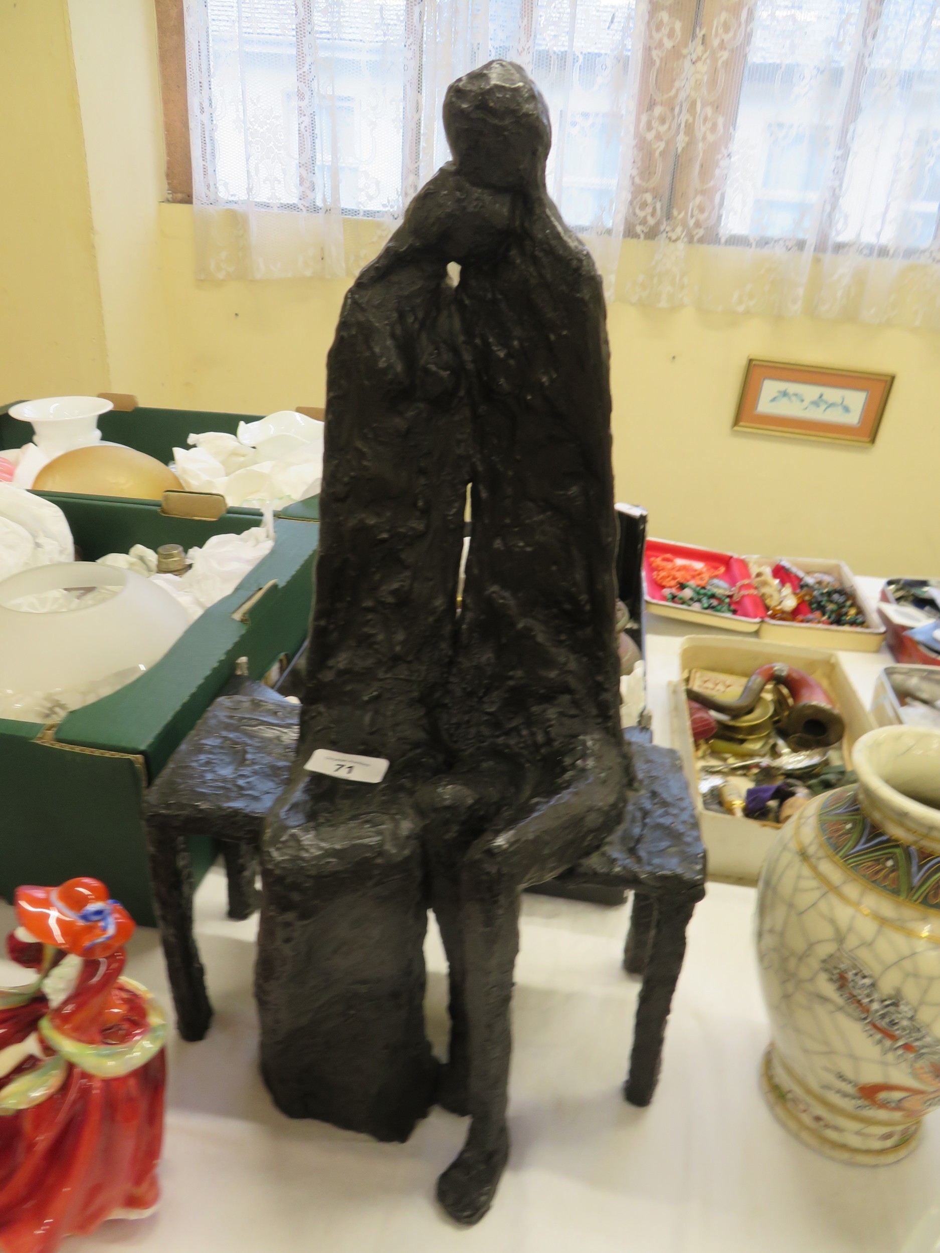 A composite statue of a couple sitting on a bench - ht. 18 ins