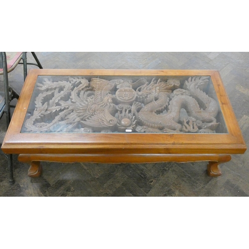 A large Chinese dragon carved teak coffee table with inset glass top
