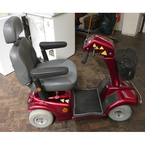 A red Rascal four wheeled mobility scooter with charger in working order