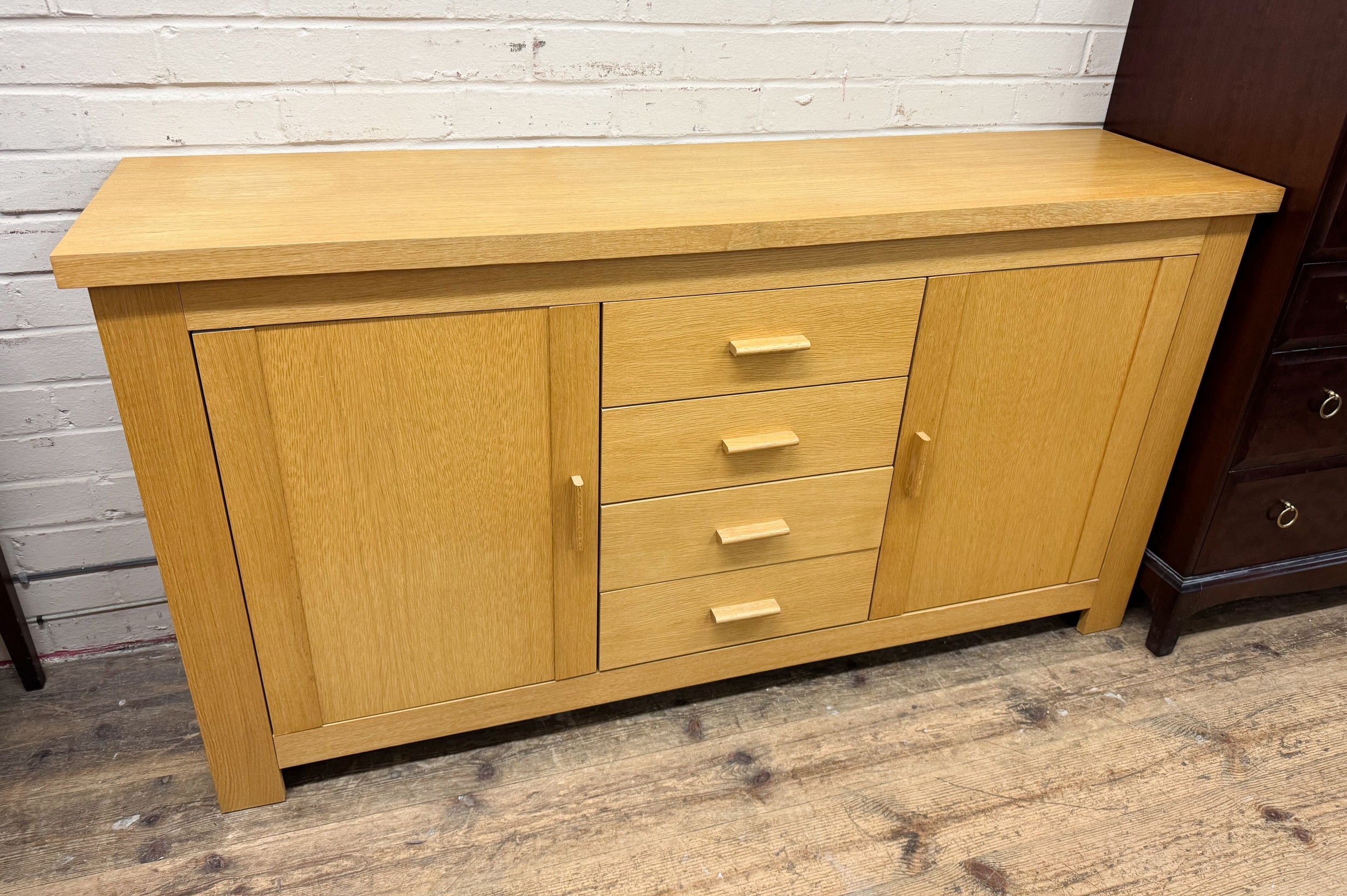 A modern light oak sideboard fitted four centre drawers and cupboards ...
