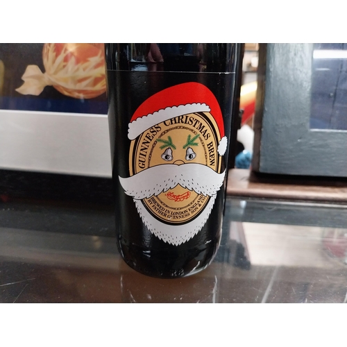 Three bottles of Guinness with Christmas labels.