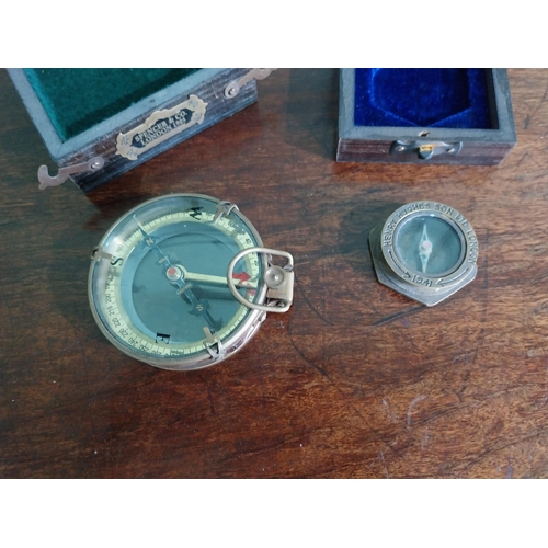 Two brass ships compasses in wooden cases.