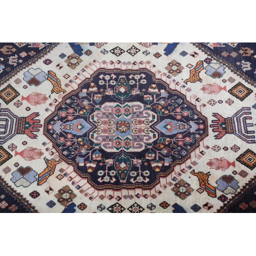 A MIDDLE EASTERN RUG, the ivory ground with indigo medallion filled ...