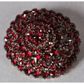 A LATE 19TH CENTURY BOHEMIAN GARNET CLUSTER BROOCH, tiered within an ...