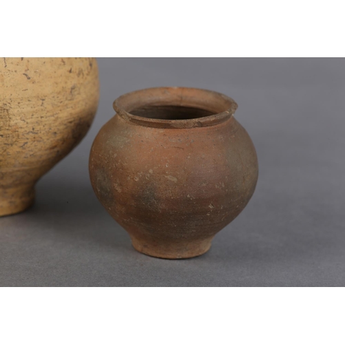 A ROMAN EARTHENWARE POT with everted rim and ovoid body, 5cm high, a ...