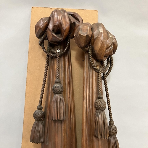 A pair of carved wooden ribboned and tasselled swags with flowering ...
