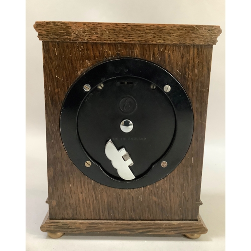 An Elliot clock in an oak case with brass dial and silvered chaptering