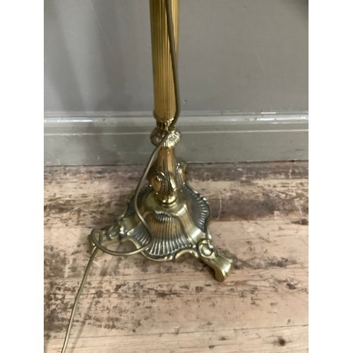 A brass reading lamp with fluted column and on tripod base