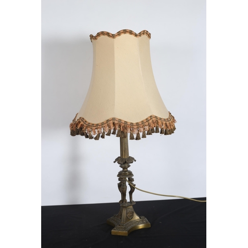 A 19TH CENTURY BRASS TABLE LAMP the reeded column raised on three ...