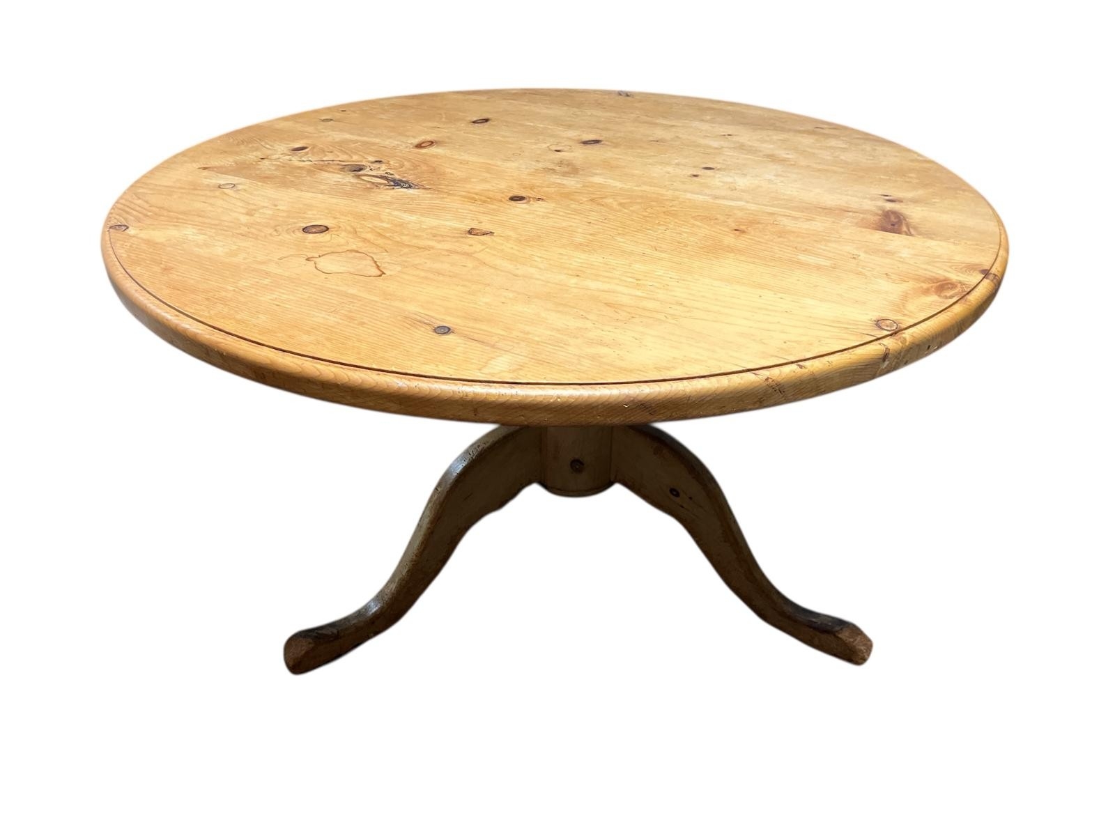 A PINE TABLE of circular outline the shaped top above a baluster column ...