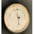 An early 20th century brass aneroid barometer, the silvered dial with ...