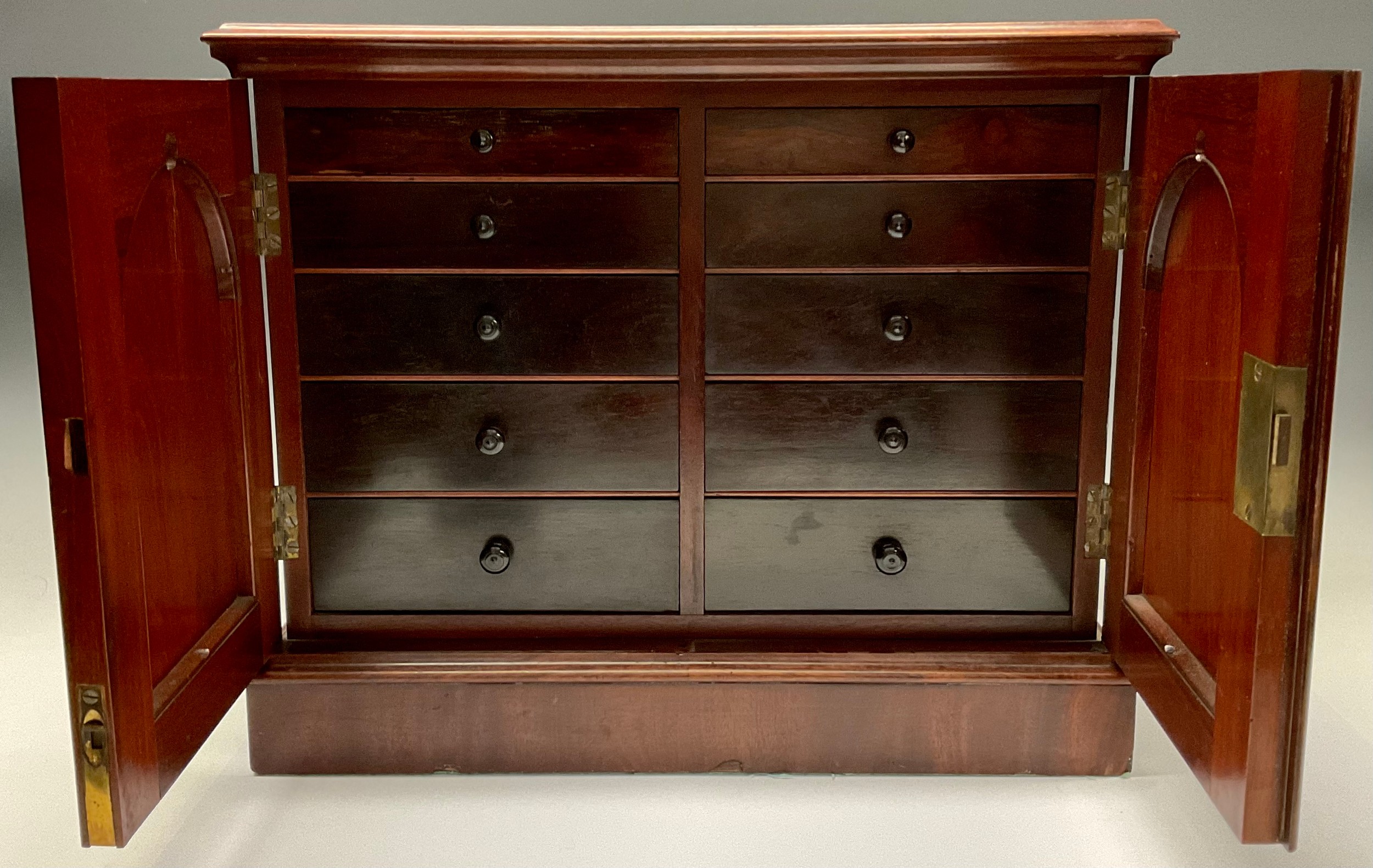 A Victorian mahogany table top collector's cabinet, oversailing top ...