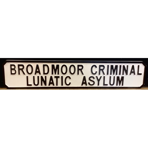 A decorative wooden sign, 'BROADMOOR CRIMINAL LUNATIC ASYLUM'